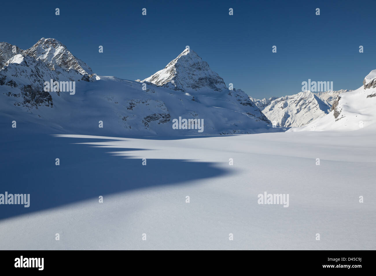 Endless snow desert with shadows from mountains Stock Photo - Alamy