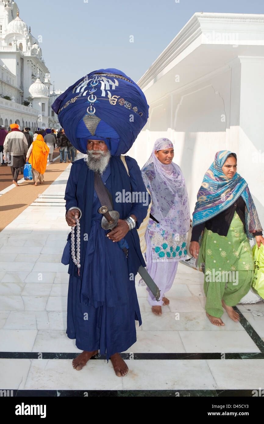 A traditionally dressed Sikh man wearing a huge turban walks around the ...