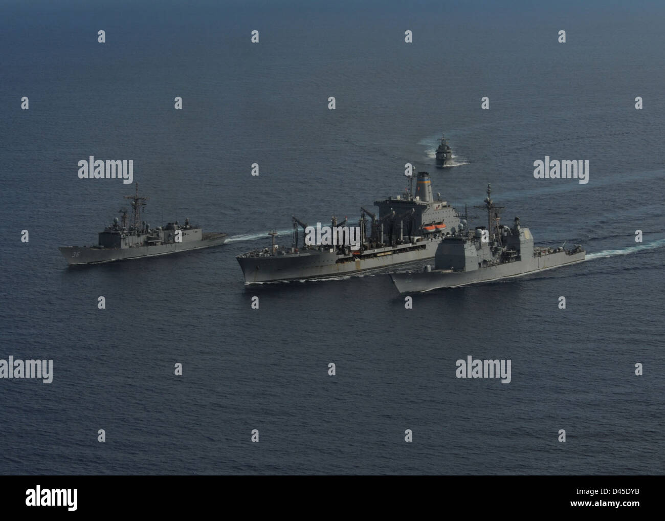 Foreign naval ships conduct a replenishment at sea operation in the ...