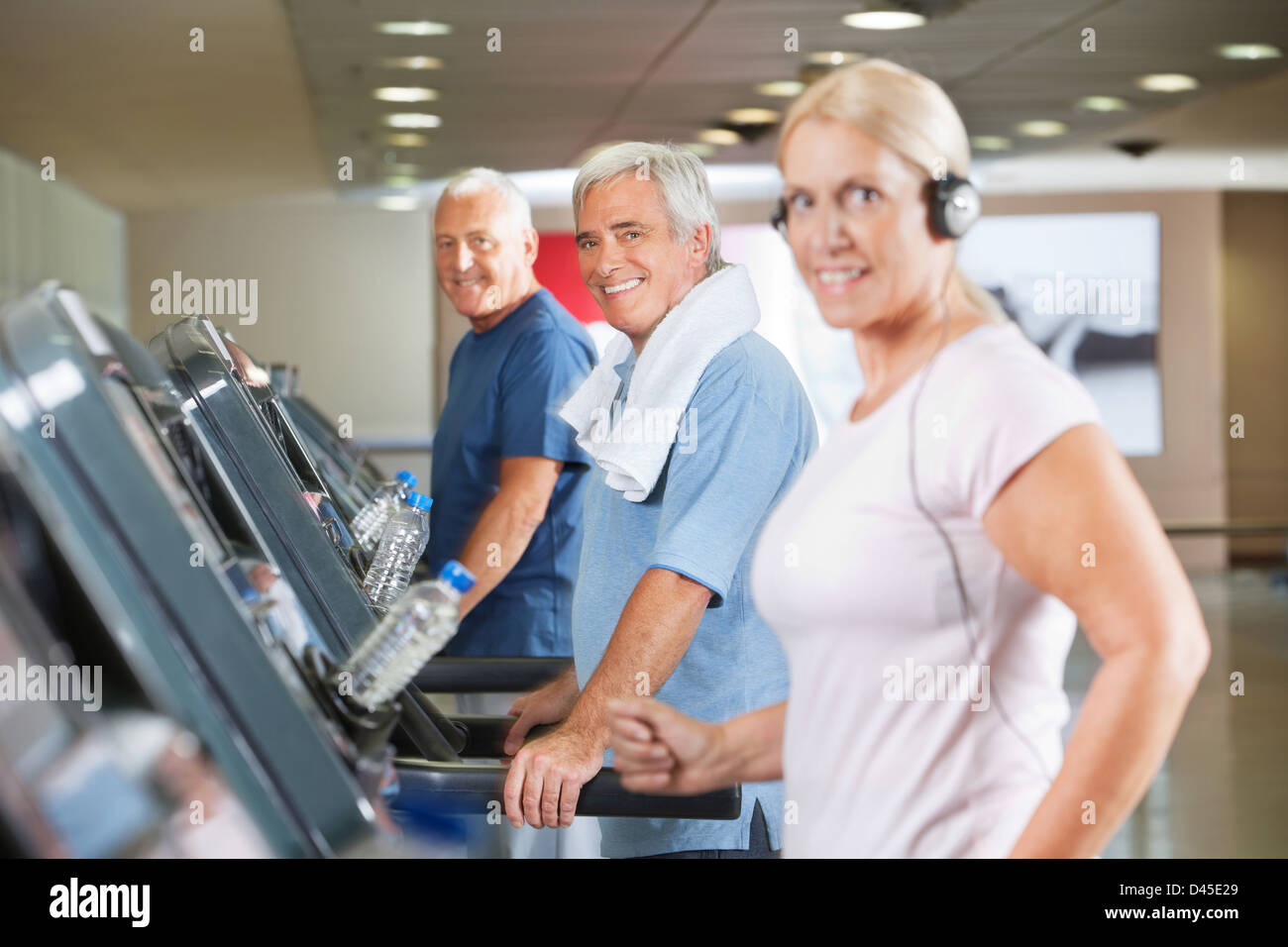 Happy senior group running on treadmills in gym Stock Photo - Alamy
