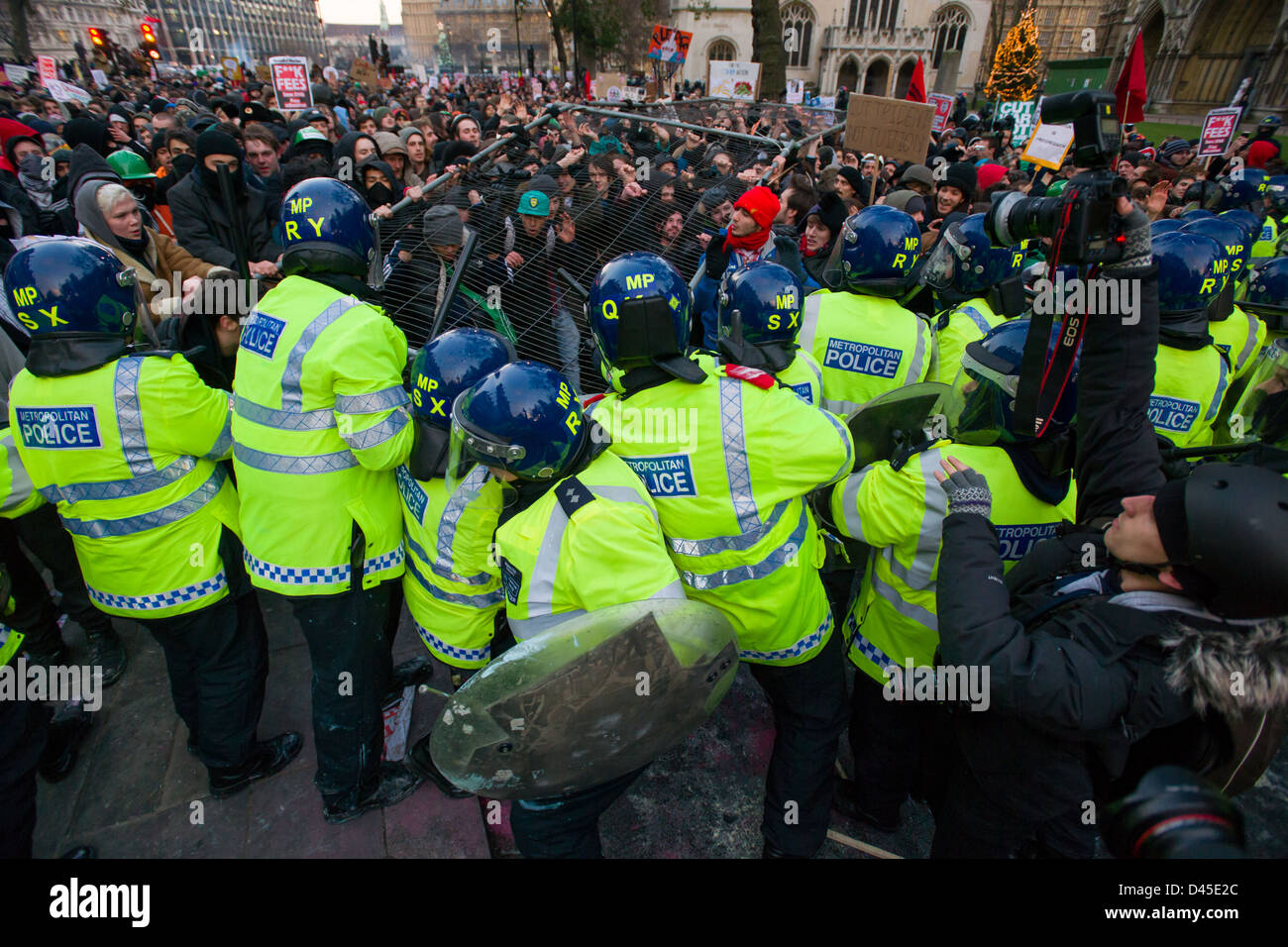 Protesting students attacking a thin line of police in full riot gear ...