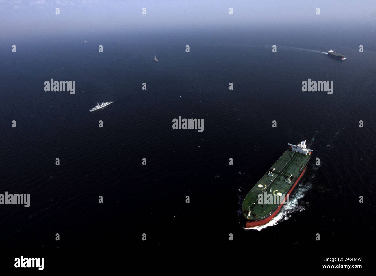 The USS Winston S. Churchill (DDG-81) escorts a commercial vessel in ...