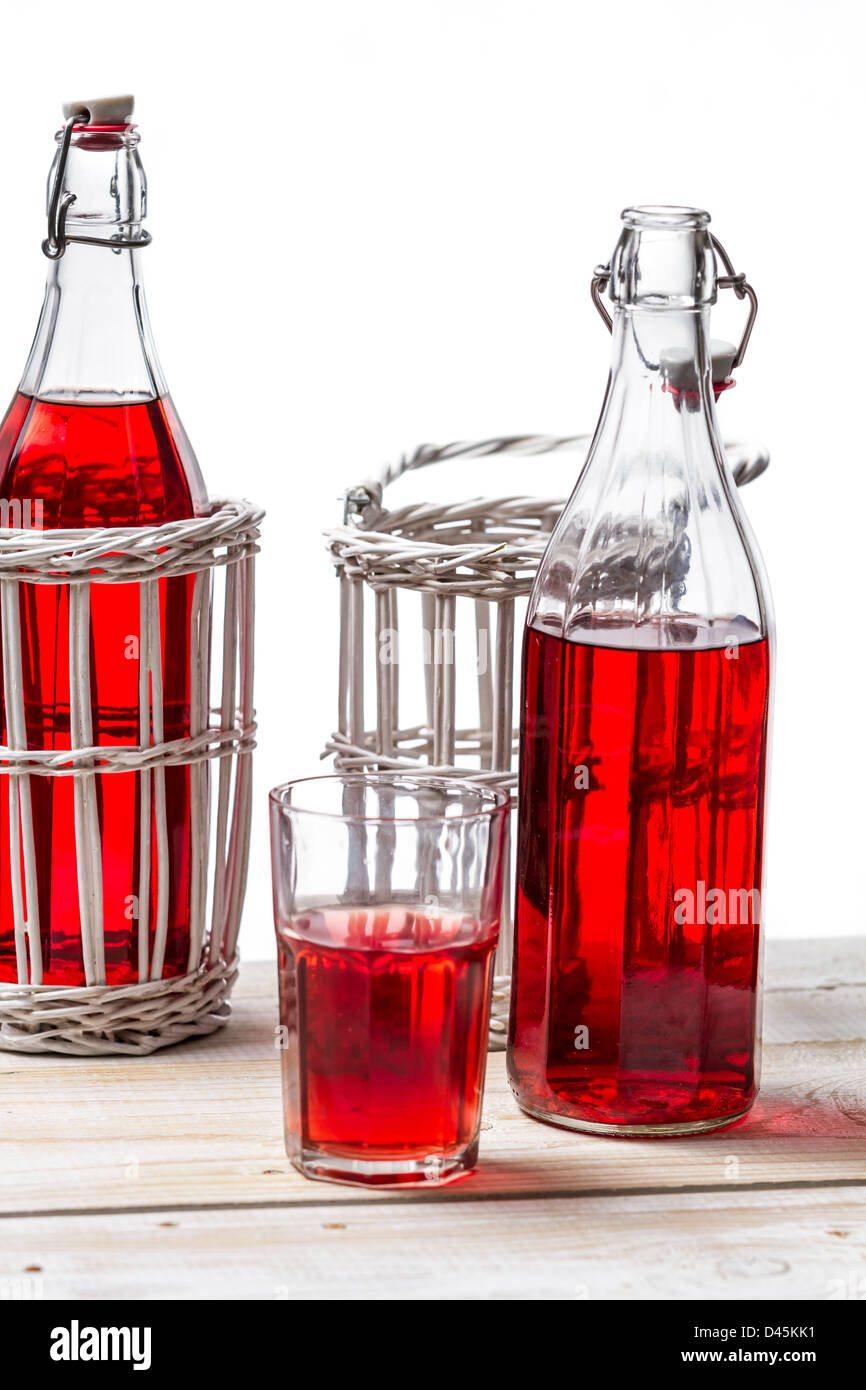 Bottles in basket with red juice on white background Stock Photo - Alamy