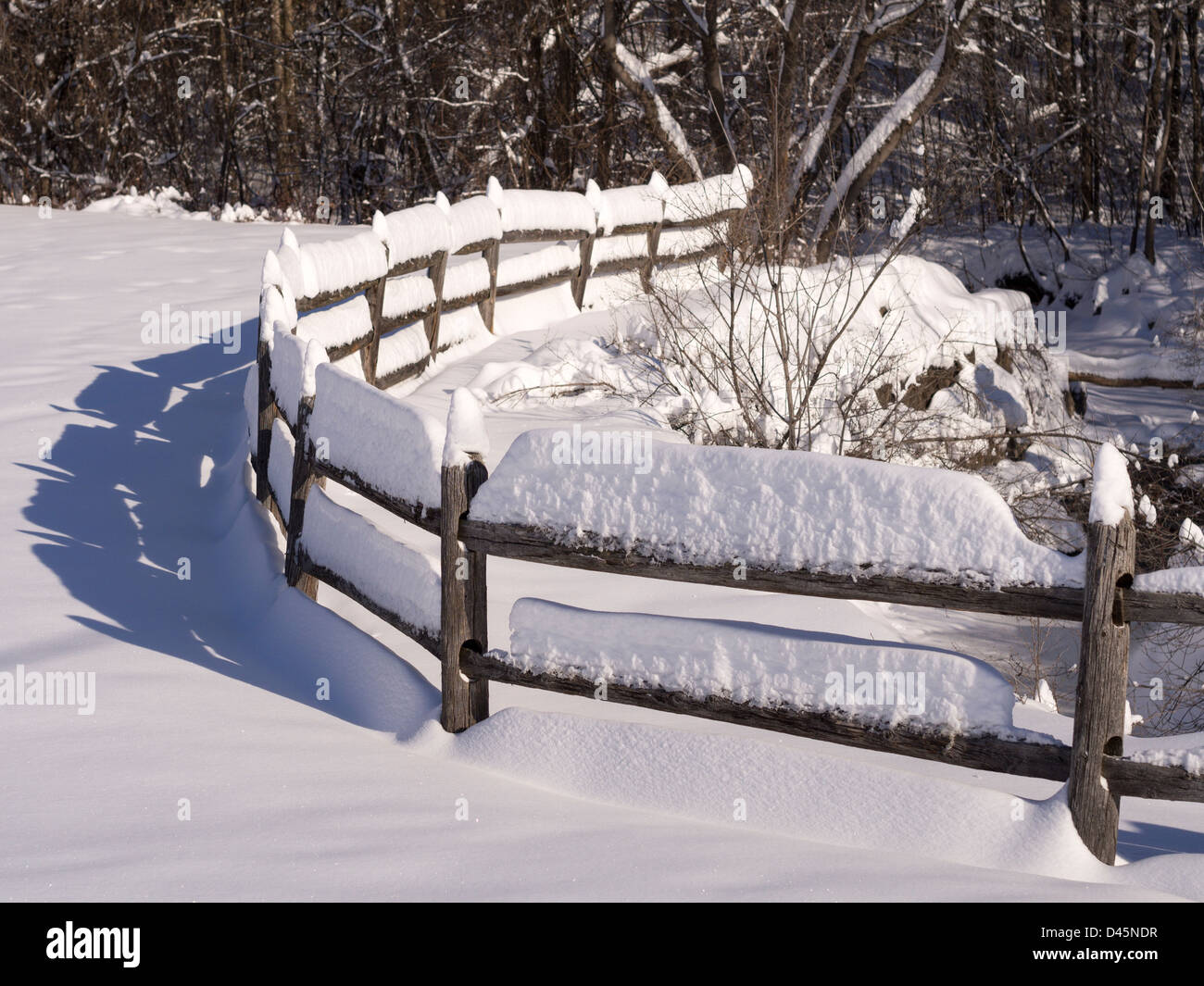 Snowy Fence. A snow covered curve of a fence in the bright sunshine ...