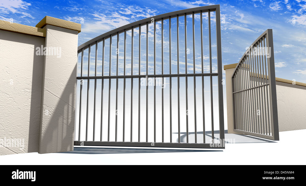 A solid garden wall with open metal gates with a blue sky in the ...