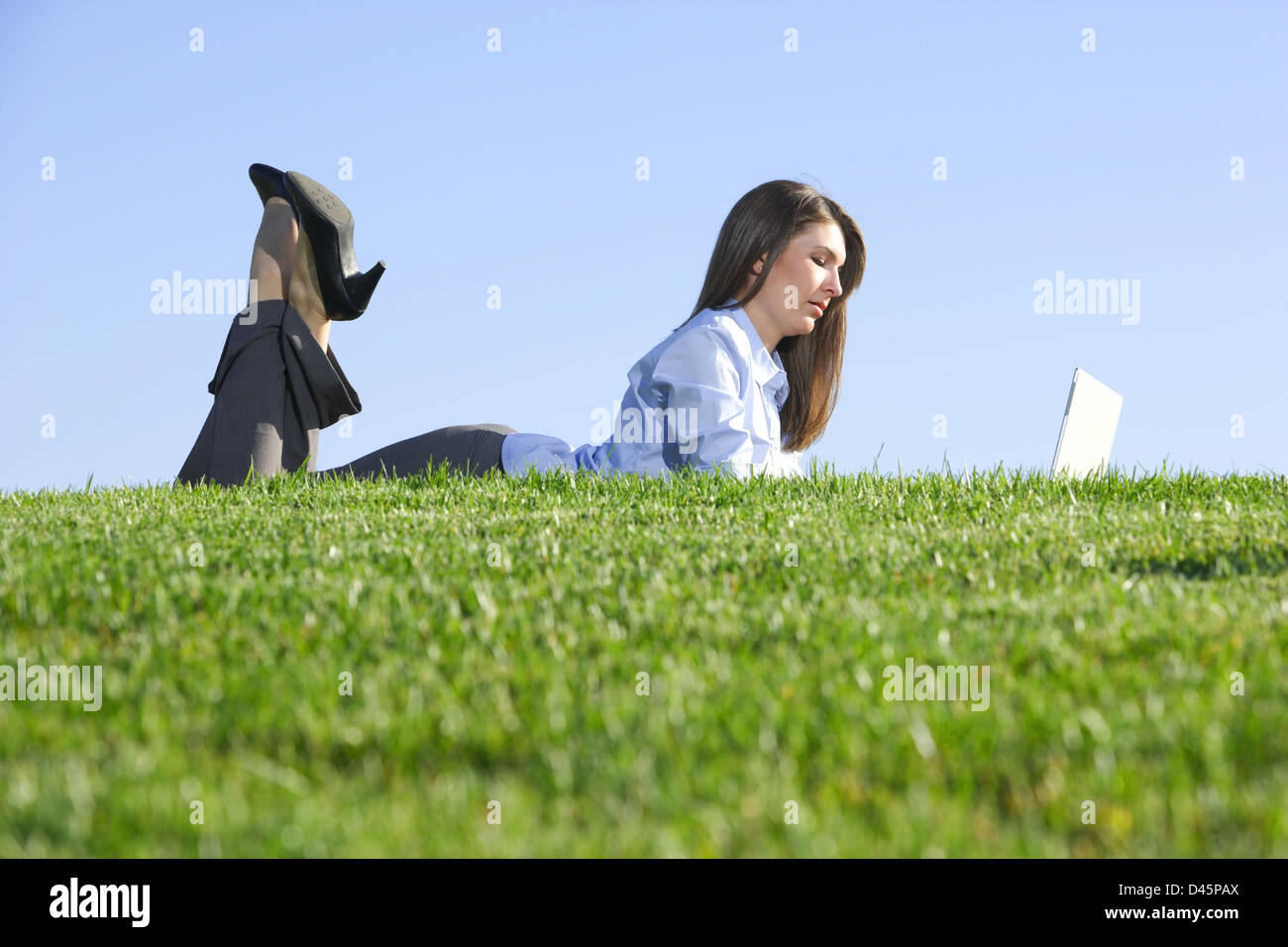 A business woman on a laptop in a field out side the office Stock Photo ...