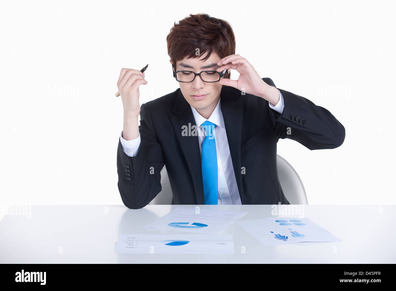 a businessman looking at chart papers Stock Photo - Alamy