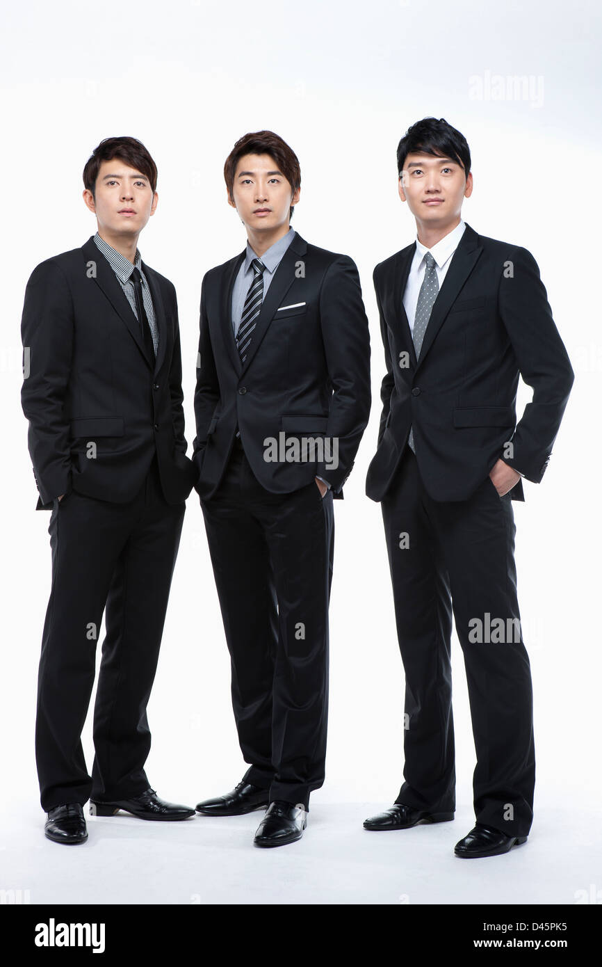 three businessmen in buisness suits posing in a line Stock Photo - Alamy