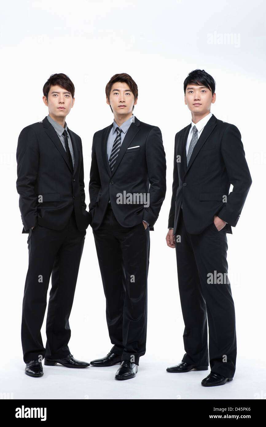three businessmen in buisness suits posing in a line Stock Photo - Alamy