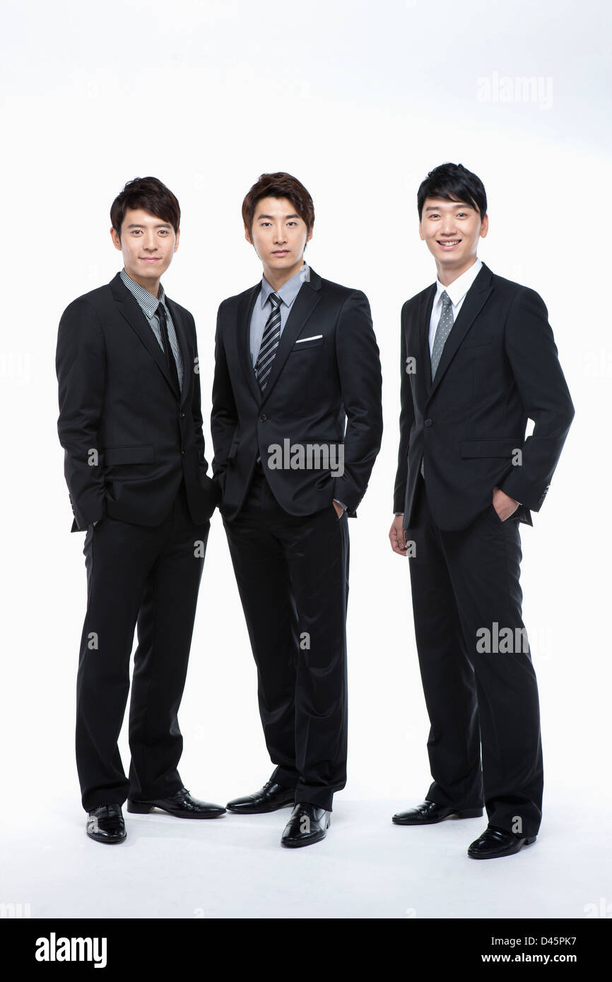 three businessmen in buisness suits posing in a line Stock Photo - Alamy