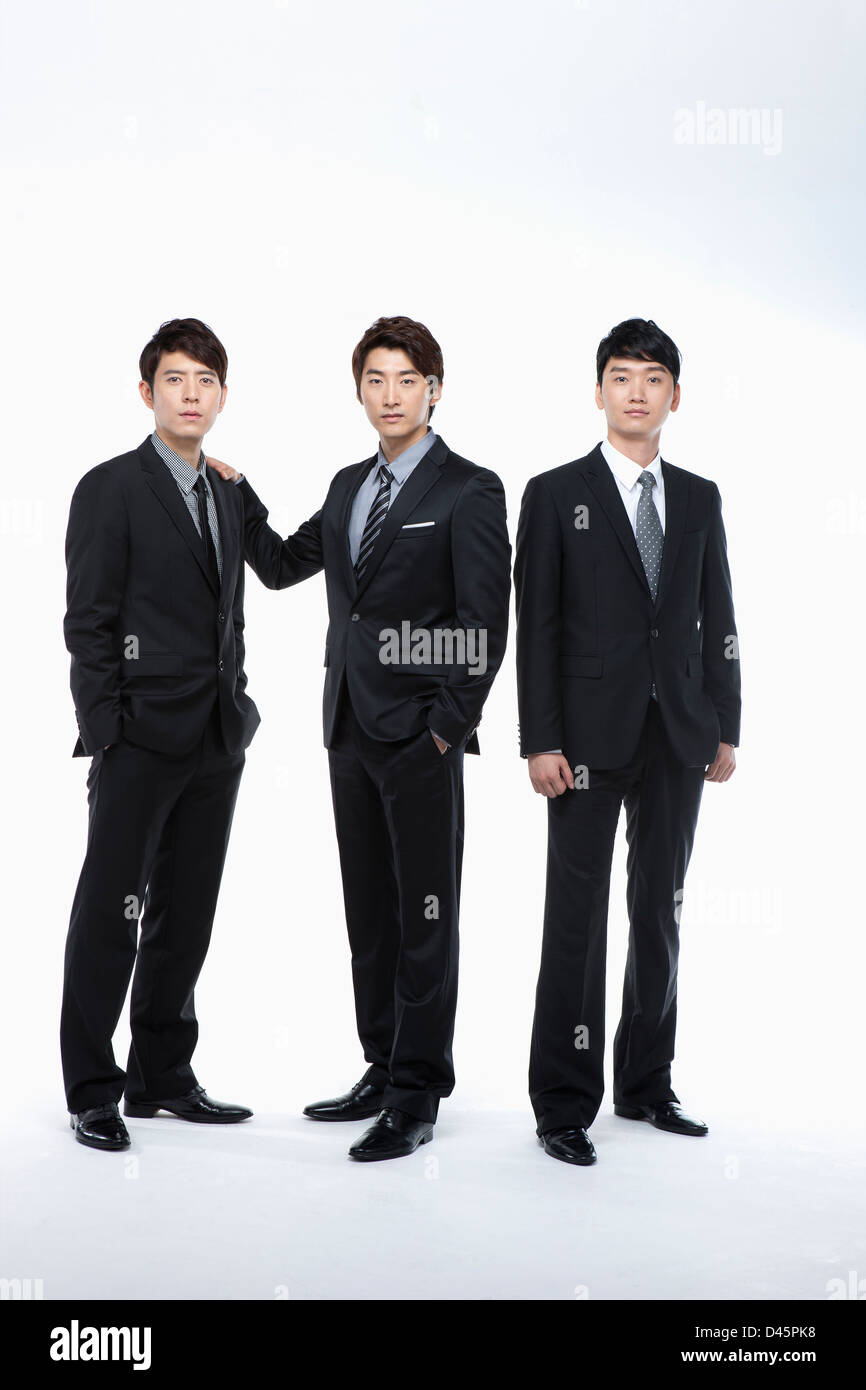 three businessmen in buisness suits posing in a line Stock Photo - Alamy