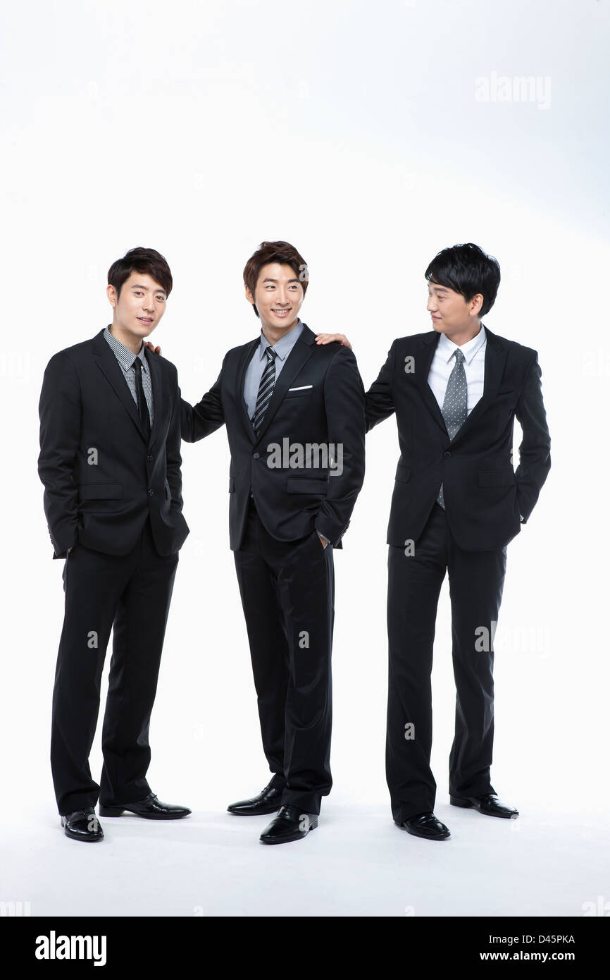 three businessmen in buisness suits posing in a line Stock Photo - Alamy