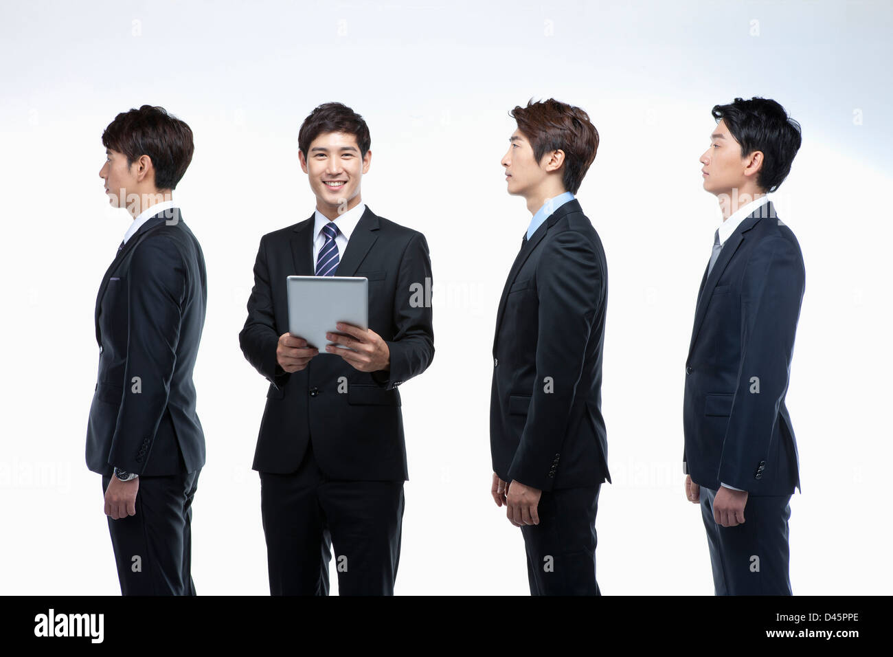 a businessman using PC tablet while other businessmen saluting in a ...