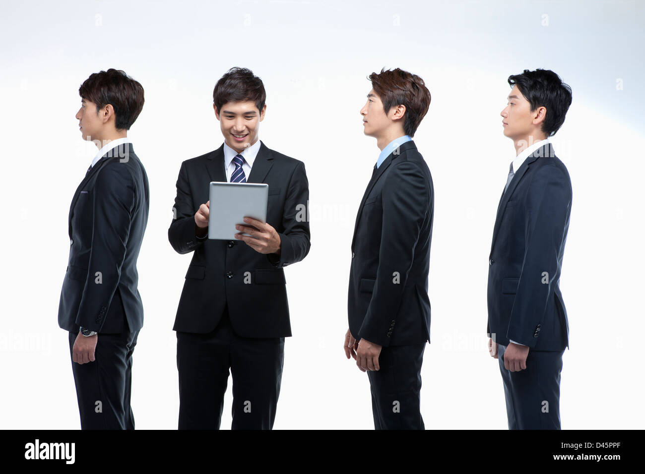 a businessman using PC tablet while other businessmen saluting in a ...