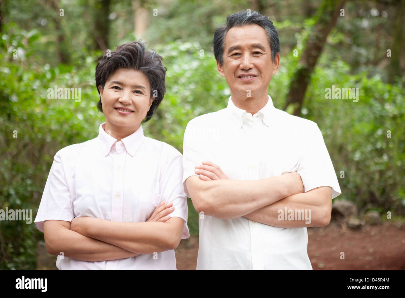 middle age couple in nature with arms crossed Stock Photo - Alamy
