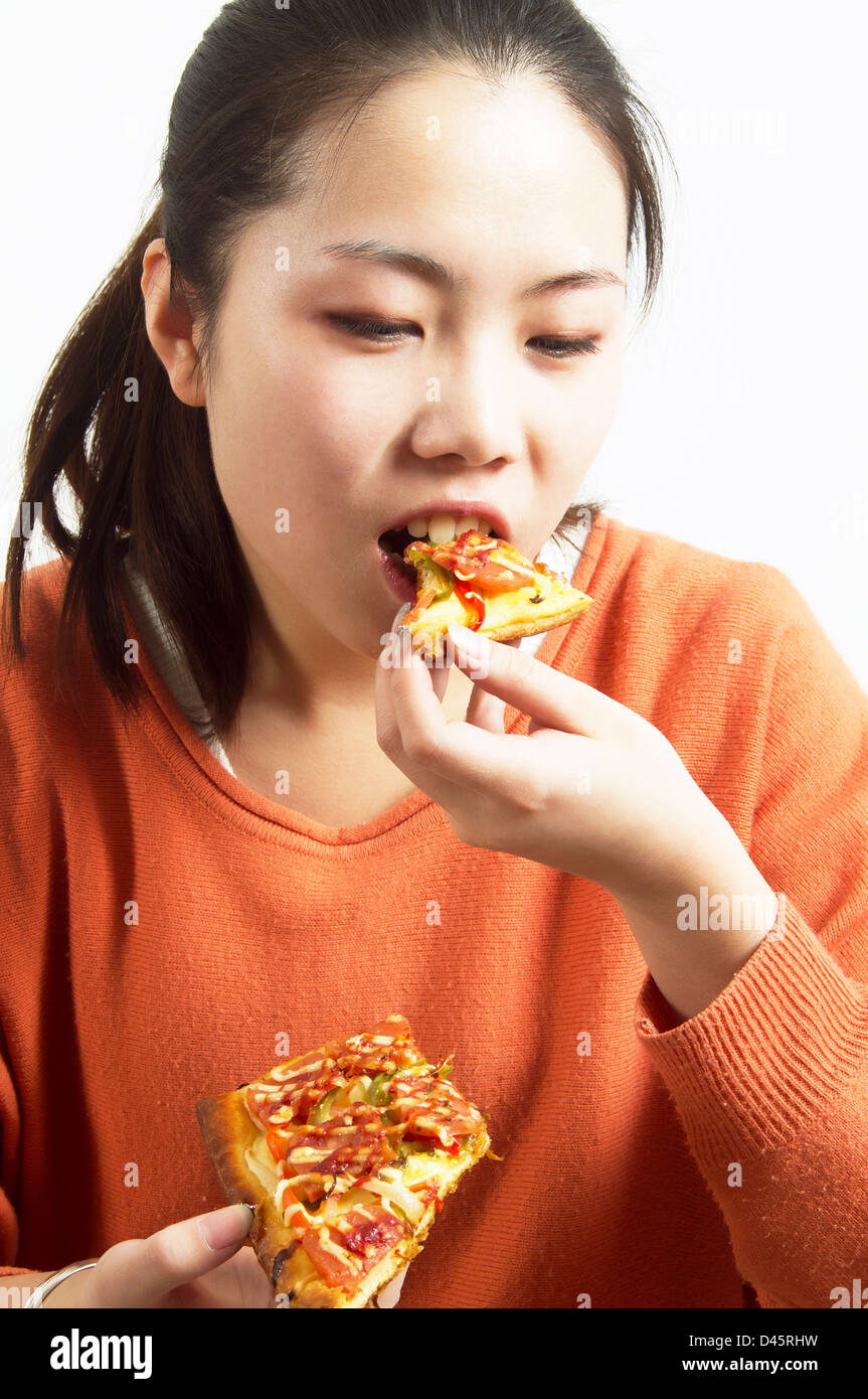 Asian girl eating delicious pizza Stock Photo - Alamy