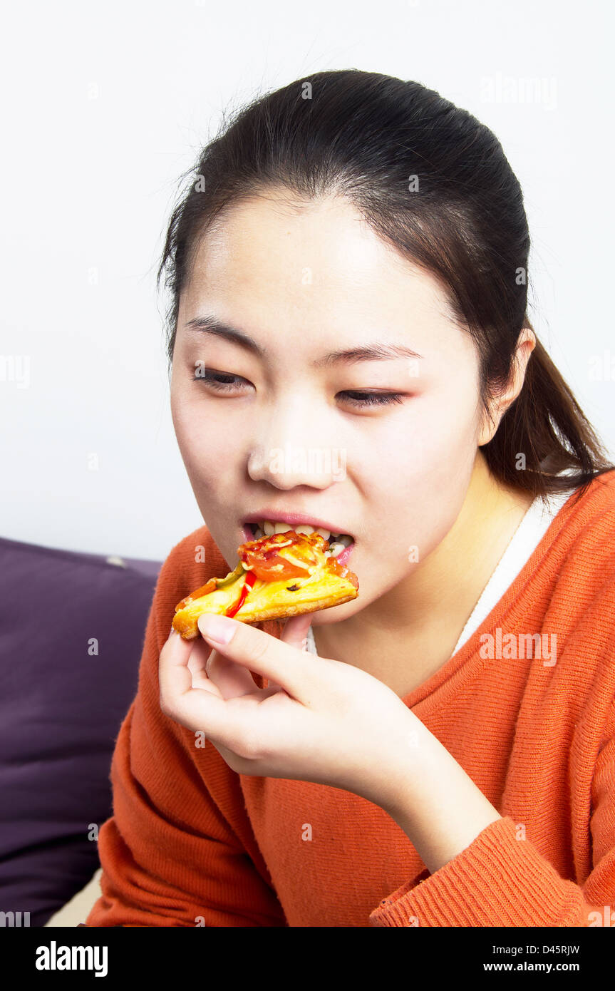 Asian girl eating delicious pizza Stock Photo - Alamy