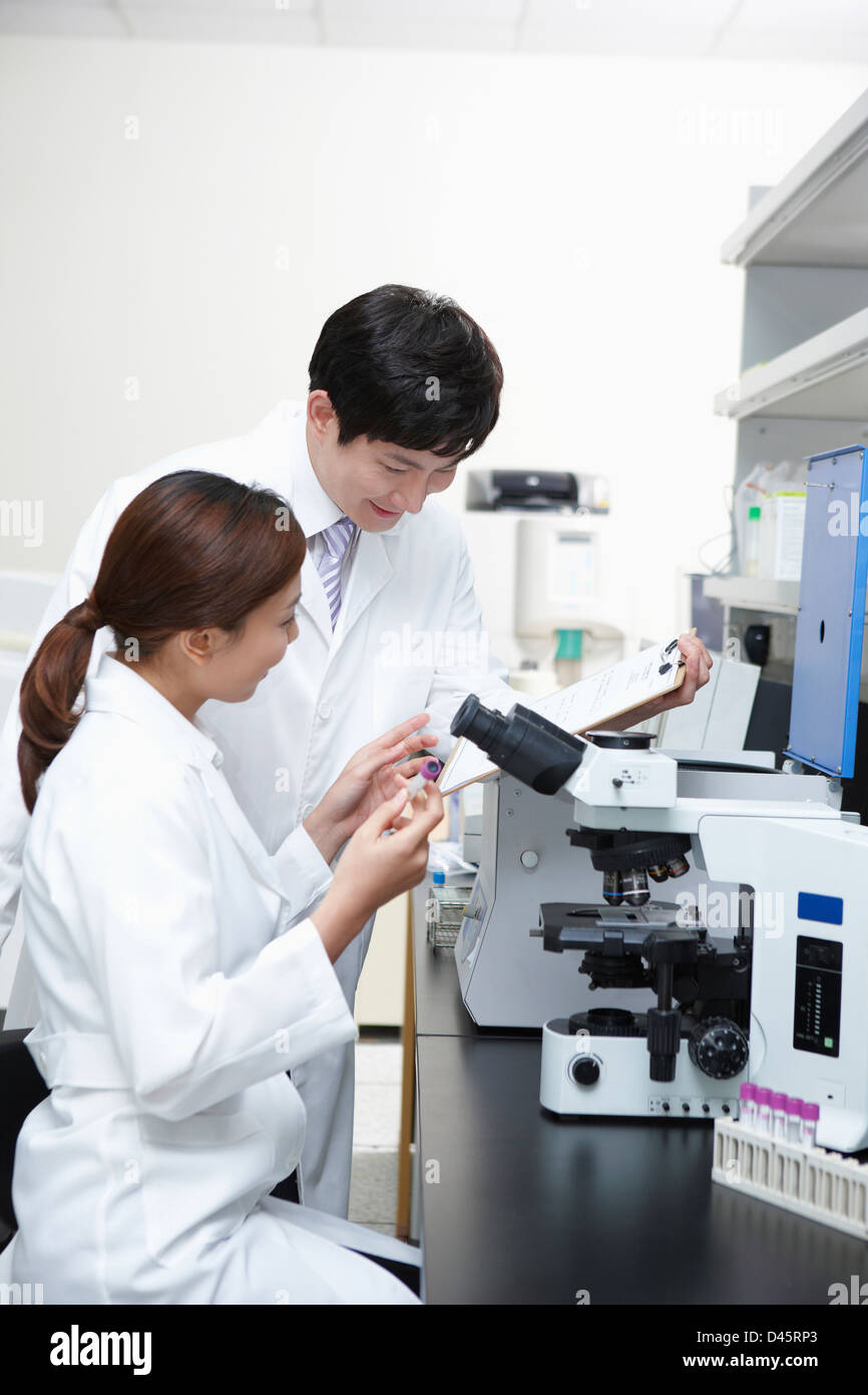 a female and male doctor with a microscope Stock Photo - Alamy