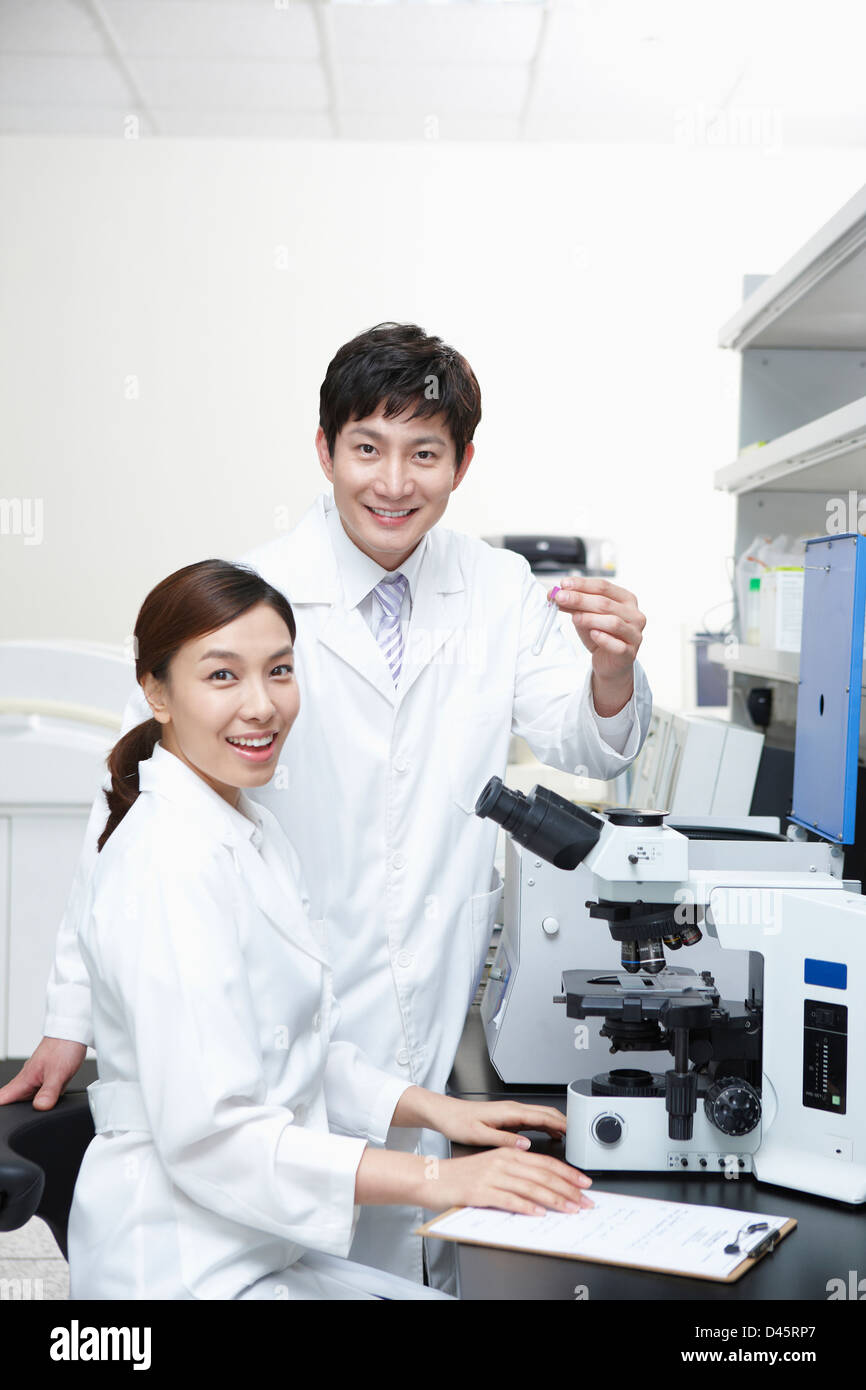 a female and male doctor with a microscope Stock Photo - Alamy