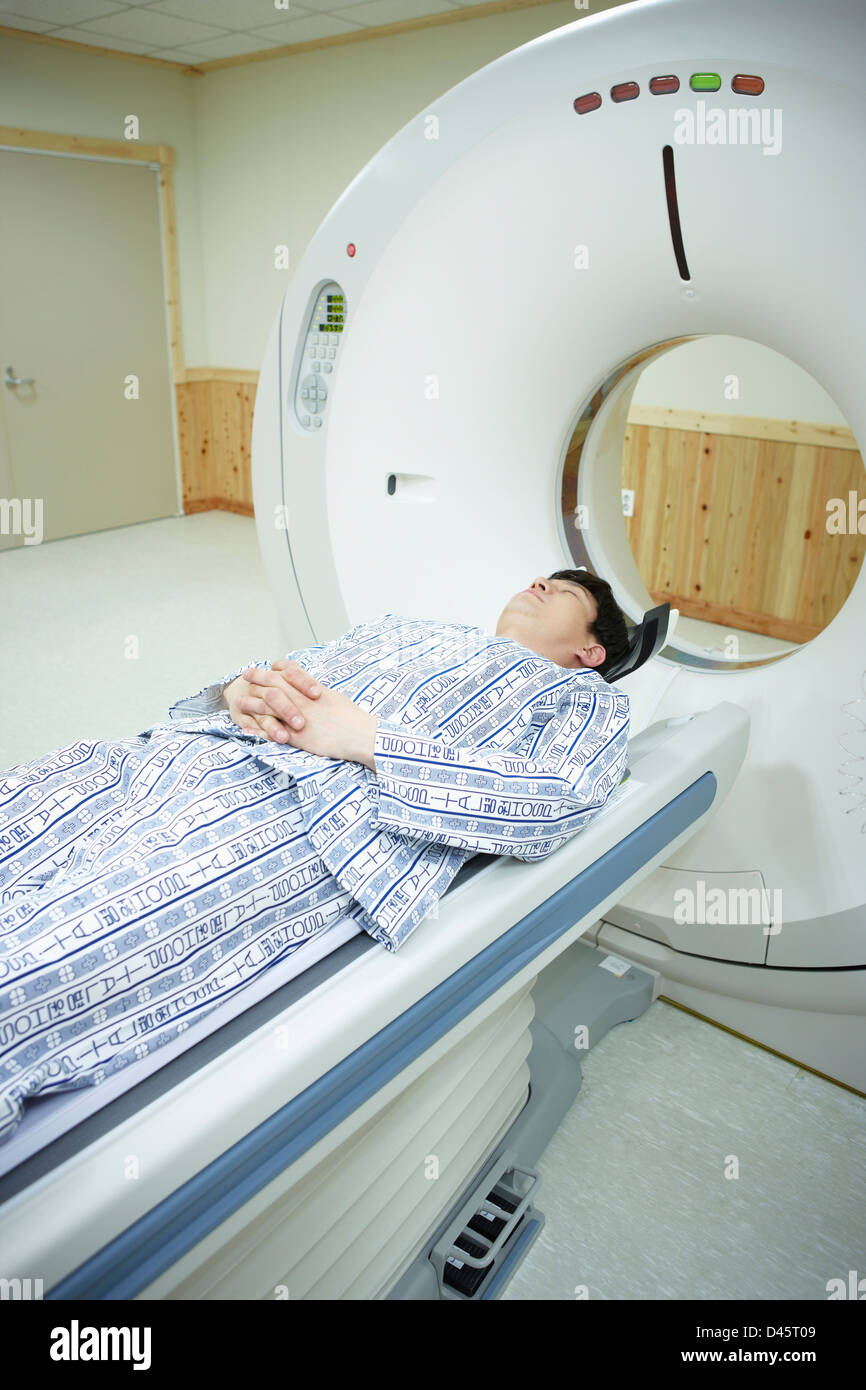 a patient lying on CT scanner bed Stock Photo - Alamy