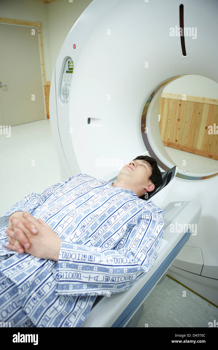 a patient lying on CT scanner bed Stock Photo - Alamy