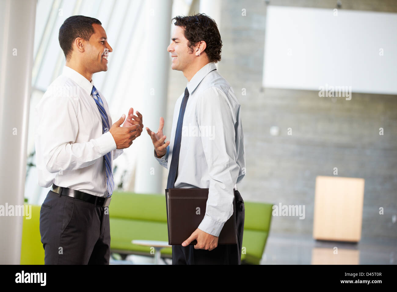 Two Businessmen Having Informal Meeting In Modern Office Stock Photo ...