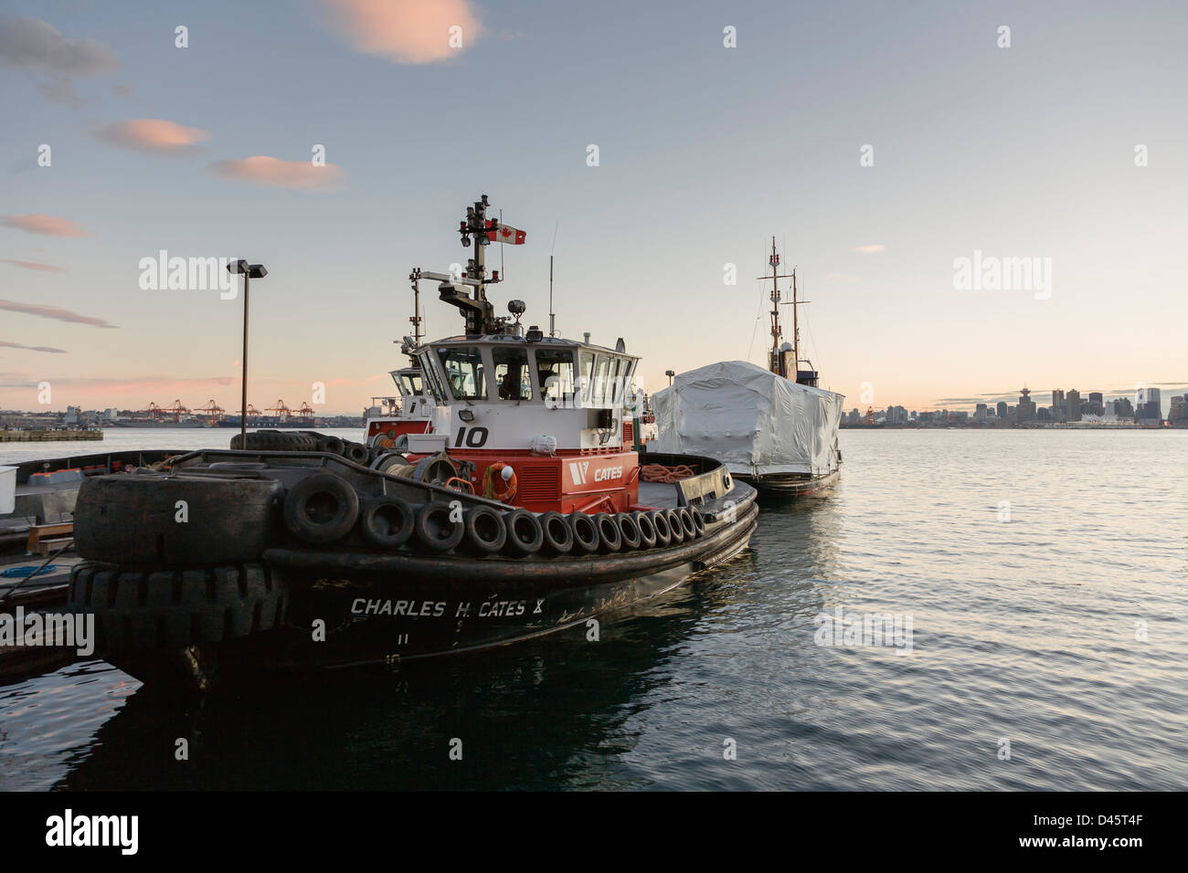 Tug boat docked at Lonsdale Quay with the Vancouver skyline beyond ...