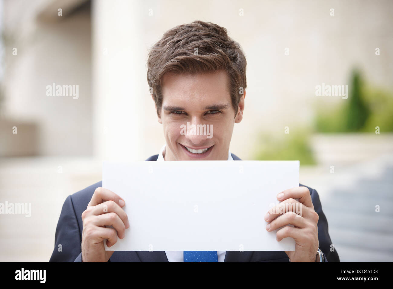 a western businessman holding a white empty paper Stock Photo - Alamy