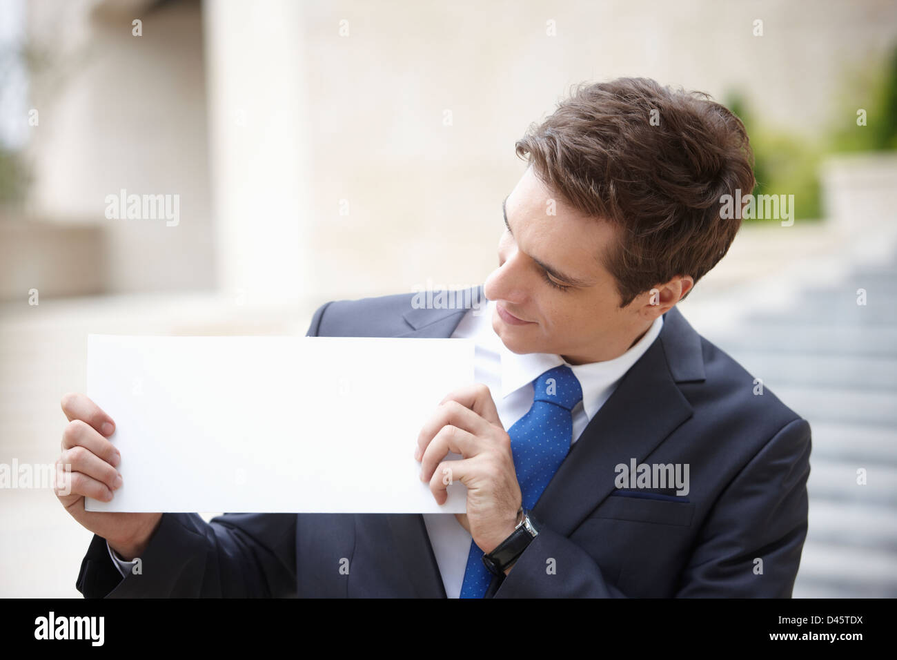 a western businessman holding a white empty paper Stock Photo - Alamy