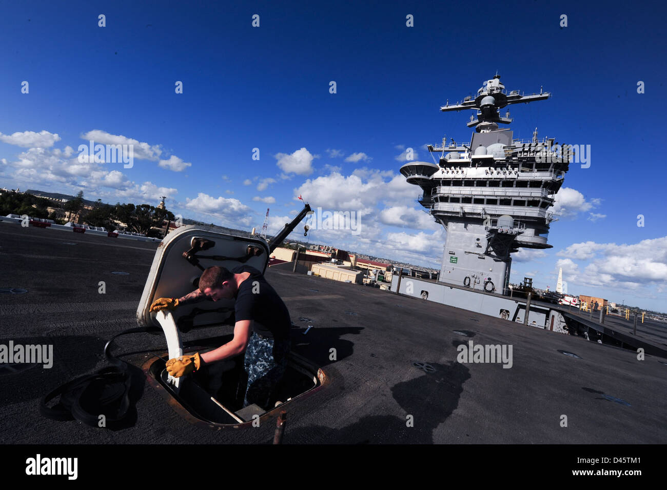 A Sailor installs a gasket on a hatch aboard a U.S. Navy vessel ...