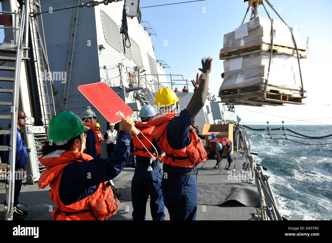 Sailors aboard a U.S. Navy vessel direct a replenishment-at-sea ...