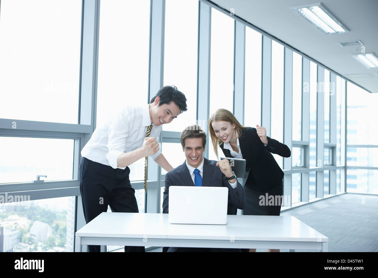 business people in a person's desk with yes pose Stock Photo - Alamy