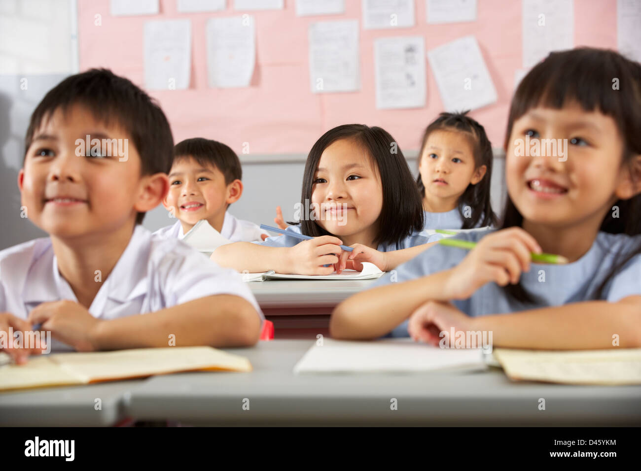Group Of Students Working At Desks In Chinese School Classroom Stock ...