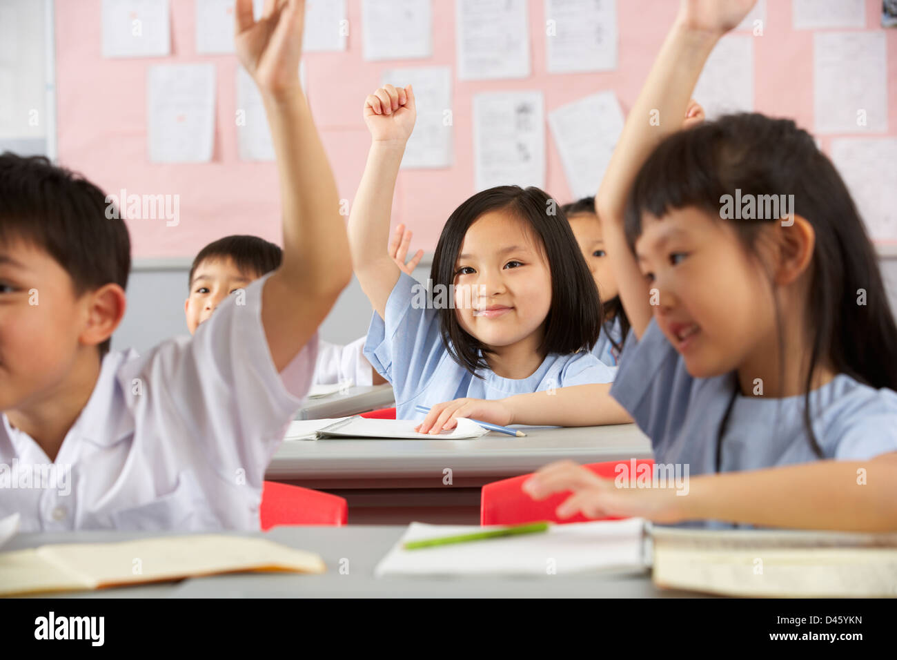 Group Of Students Arms Up In Classroom High Resolution Stock ...