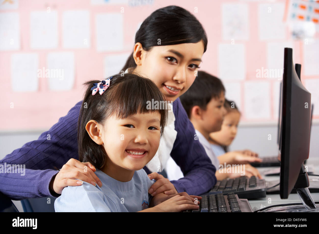 Teacher Helping Student During Computer Class In Chinese School ...