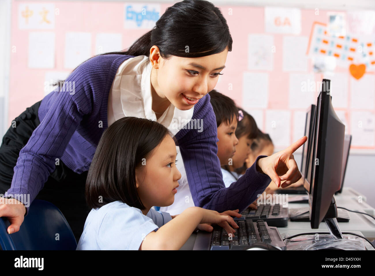 Teacher Helping Student During Computer Class In Chinese School ...