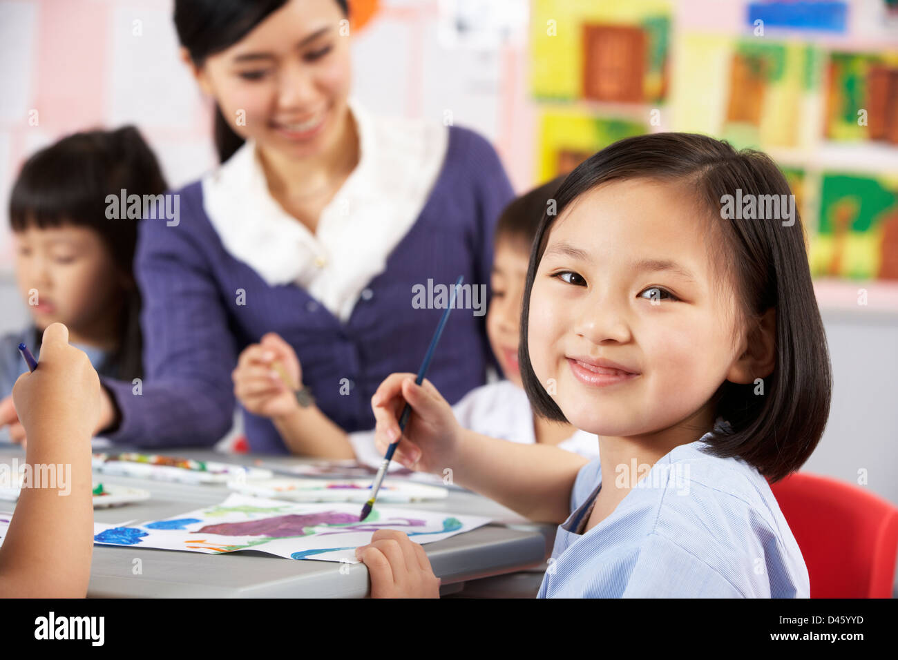 Female Pupil Enjoying Art Class In Chinese School Classroom Stock Photo ...