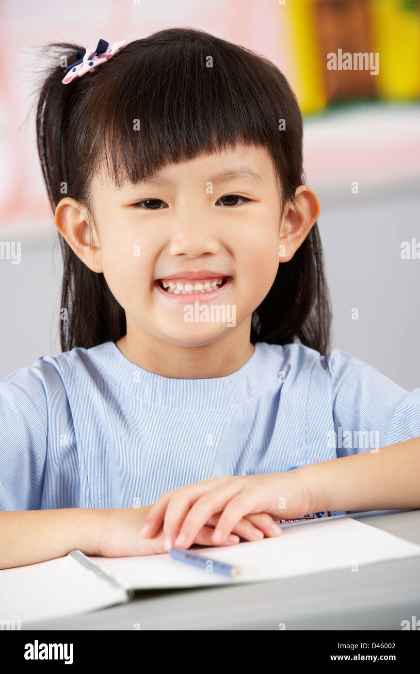 Female Student Working At Desk In Chinese School Classroom Stock Photo ...