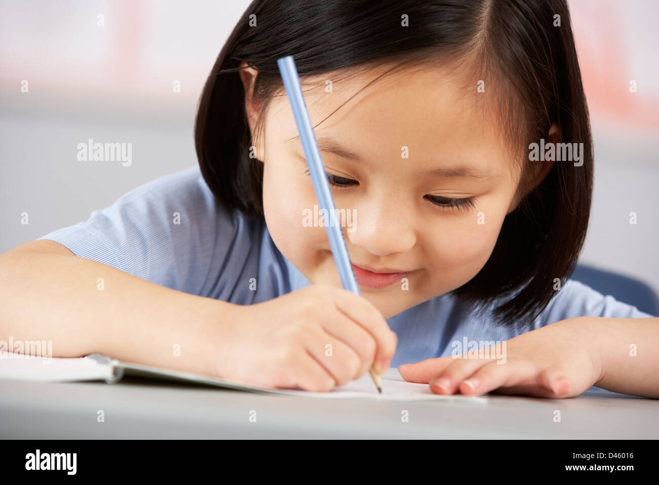 Female Student Working At Desk In Chinese School Classroom Stock Photo ...