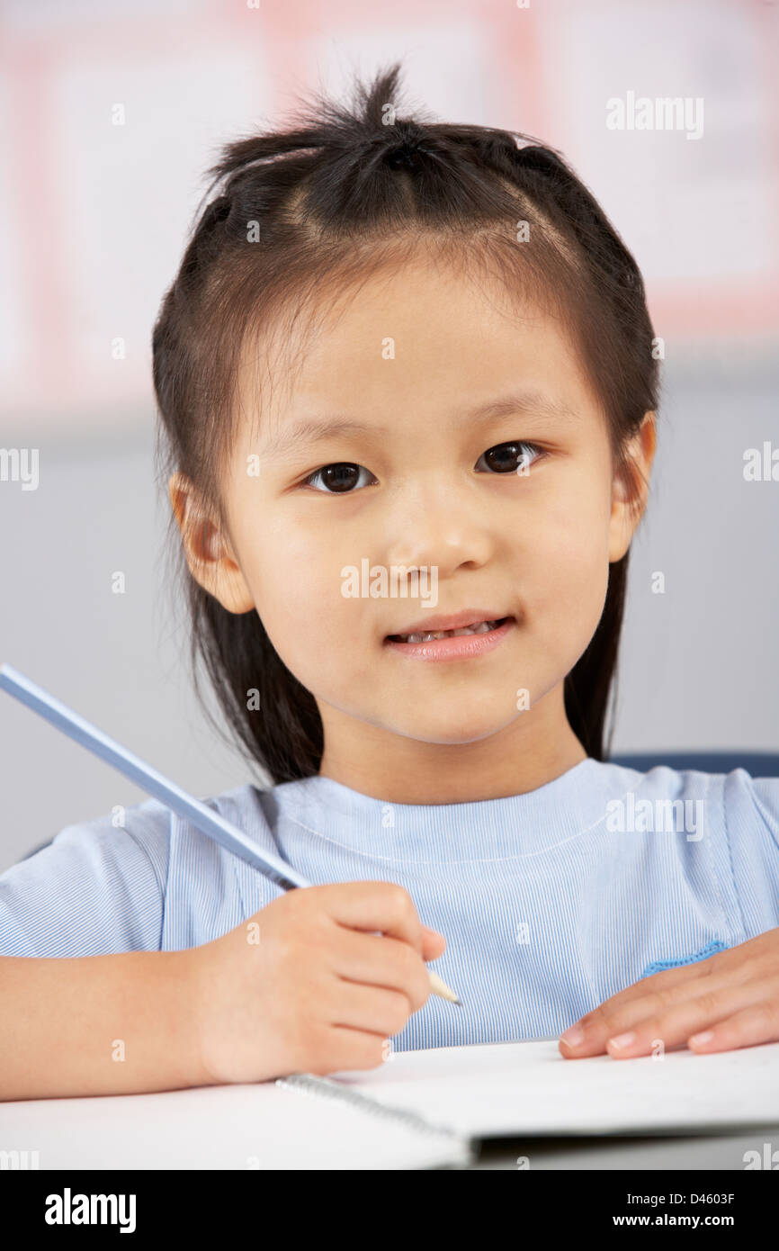Female Student Working At Desk In Chinese School Classroom Stock Photo ...