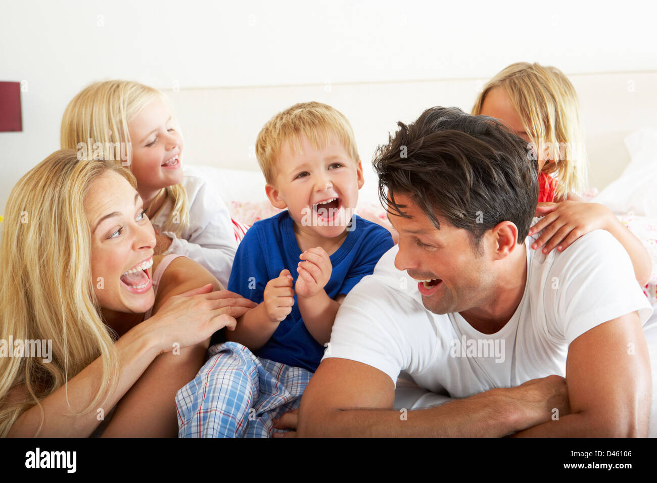 Family Relaxing Together In Bed Stock Photo - Alamy