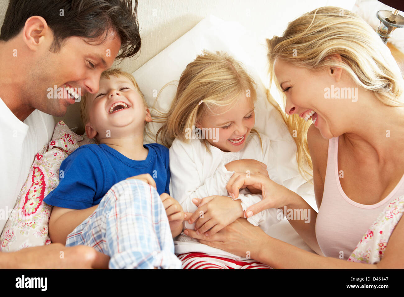Family Relaxing Together In Bed Stock Photo - Alamy