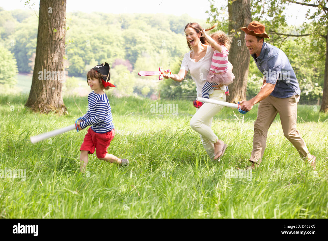 Parents Playing Exciting Adventure Game With Children In Summer Field ...