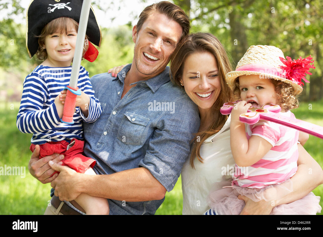 Parents Playing Exciting Adventure Game With Children In Summer Field ...