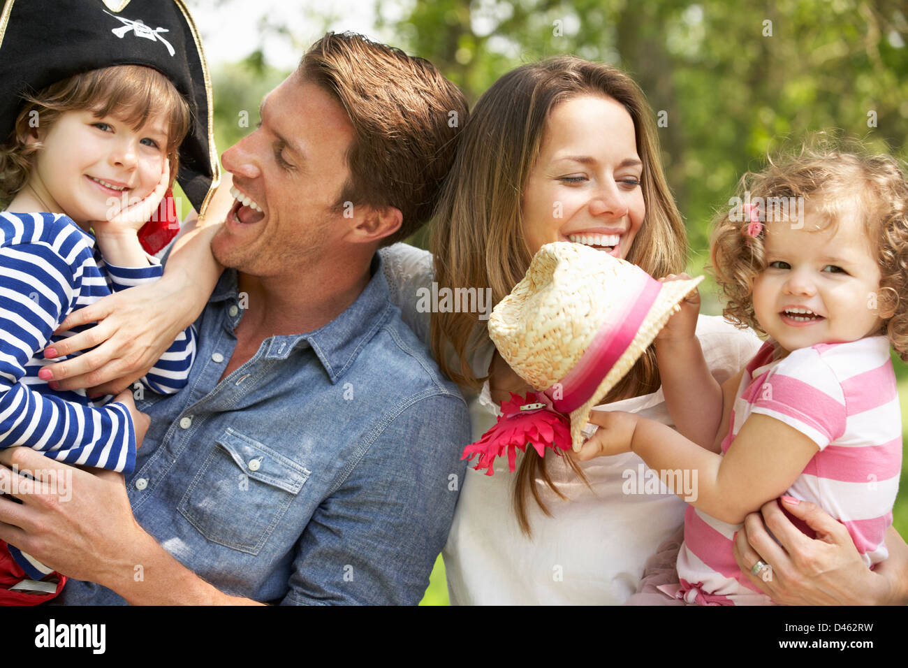 Parents Playing Exciting Adventure Game With Children In Summer Field ...