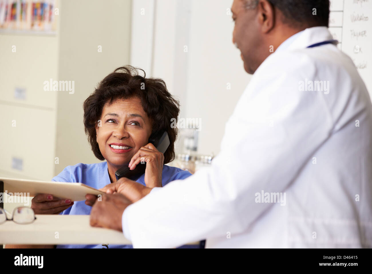 Doctor In Discussion With Nurse At Nurses Station Stock Photo - Alamy