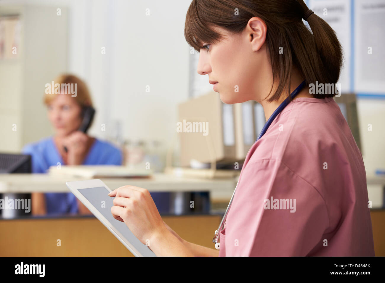 Nurse Using Mobile Phone At Nurses Station Stock Photo - Alamy