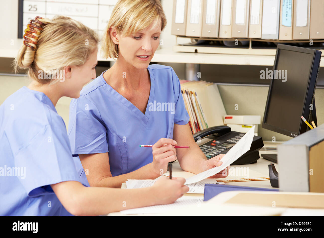 Two Nurses Working At Nurses Station Stock Photo - Alamy