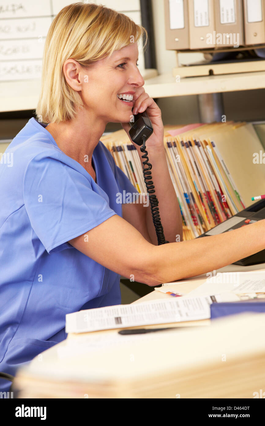 Nurse Making Phone Call At Nurses Station Stock Photo - Alamy
