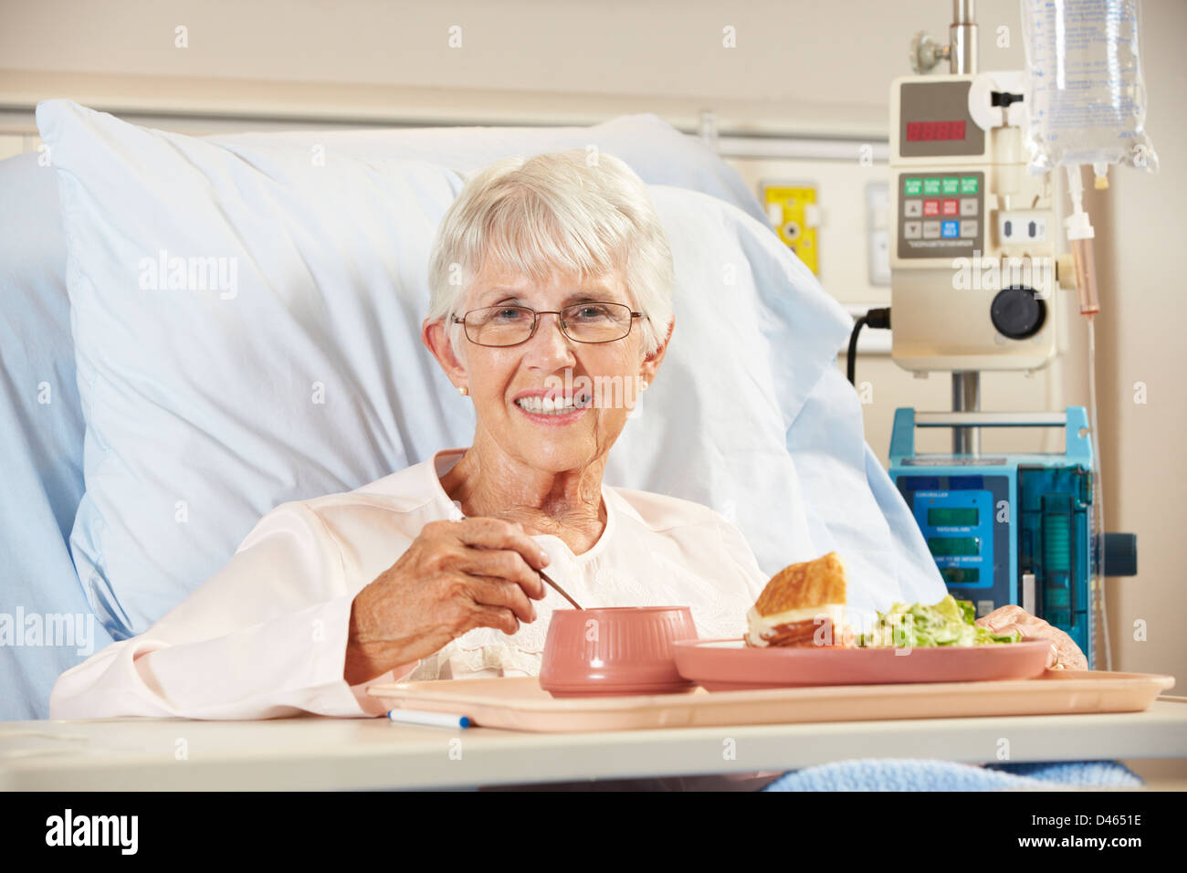 Senior Female Patient Eating Meal In Hospital Bed Stock Photo - Alamy